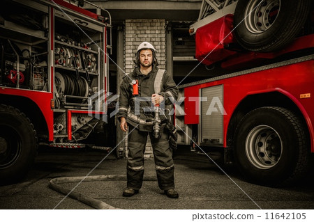 Stock Photo: Firefighter near truck with equipment with water water ...