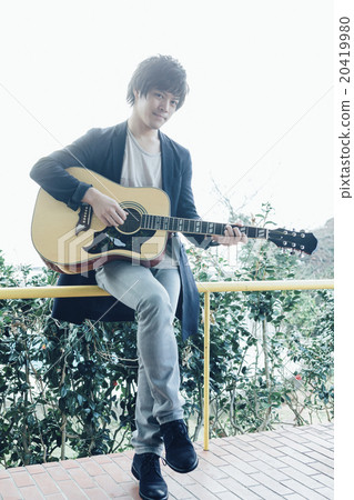 College student playing guitar on terrace - Stock Photo [20419980] - PIXTA
