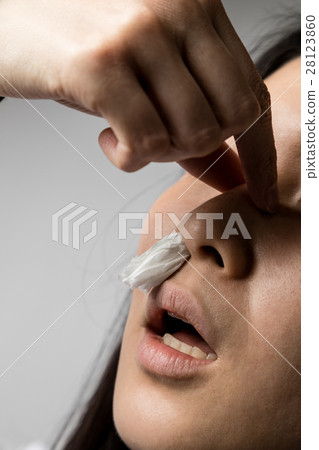 A woman holding a tissue in her nose - Stock Photo [28123860] - PIXTA