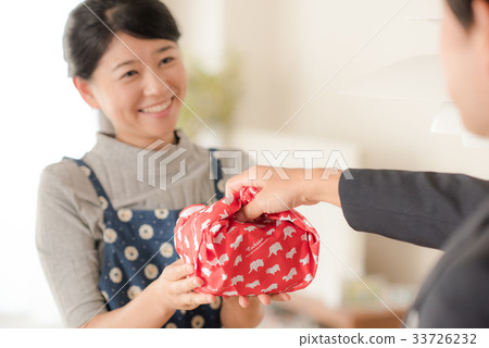 Japanese woman handing over a handmade lunch box - Stock Photo ...