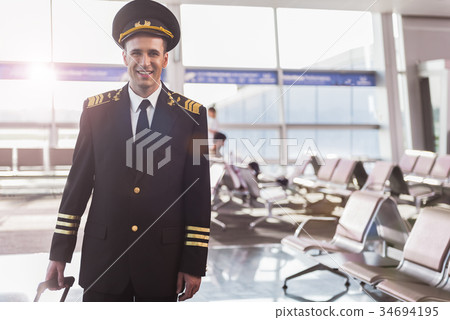 Cheerful smiling pilot in terminal - Stock Image - Everypixel