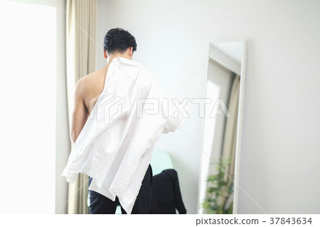 Businessman putting on a shirt - Stock Photo [37843634] - PIXTA