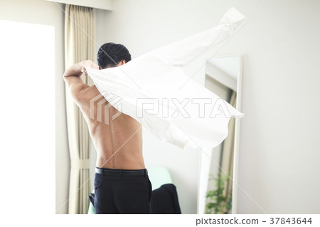 Businessman putting on a shirt - Stock Photo [37843644] - PIXTA