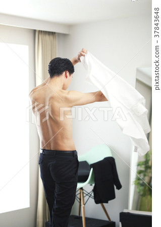 Businessman putting on a shirt - Stock Photo [37843648] - PIXTA