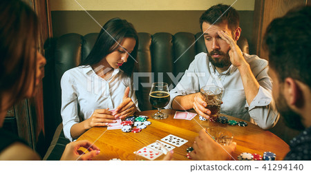 Side view photo of friends sitting at wooden table. Friends having fun ...