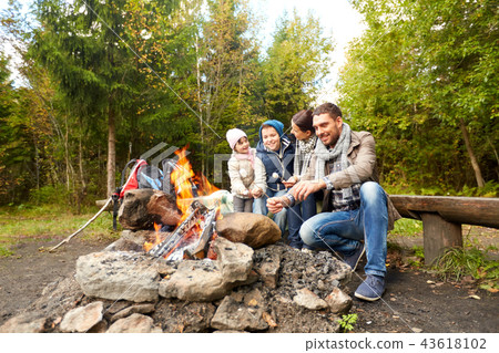 happy family roasting marshmallow over campfire - Stock Image - Everypixel