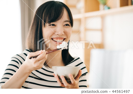 Young Japanese woman eating rice with chopsticks - Stock Photo ...
