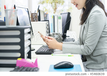 A woman watching a smartphone at the office - Stock Photo [45460639 ...