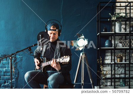 Close up of a man singer sitting on a stool in a - Stock Image - Everypixel