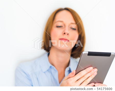 Young woman reading on her tablet and smiling - Stock Photo [54175600 ...