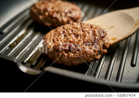 Closeup of juicy burgers fried on black grill pan - Stock Image ...
