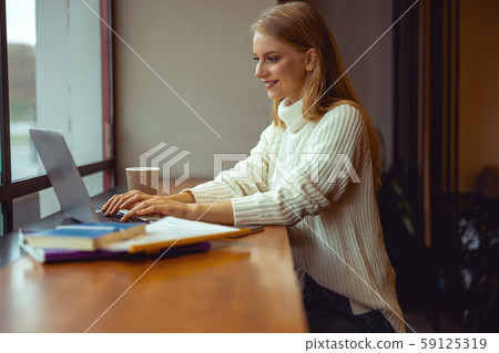 Lovely woman working on her laptop indoors - Stock Photo [59125319] - PIXTA