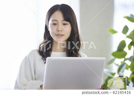Young woman searching the net on a laptop - Stock Photo [62195416] - PIXTA