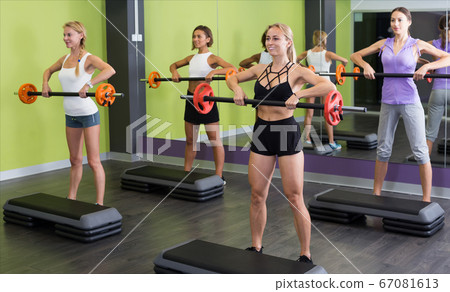 Smiling girls performing weight lifting workout... - Stock Photo ...