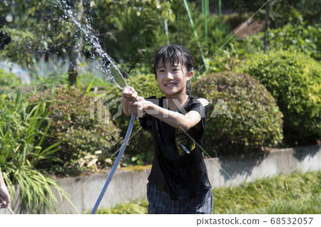 Girl spraying water with a hose Female person... - Stock Photo ...