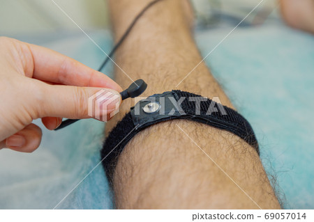 Woman doctor puts a sensor on the patient's leg. - Stock Photo ...