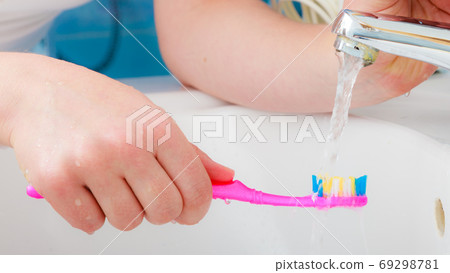 Toothpaste on toothbrush in hand, in the bathroom - Stock Photo ...