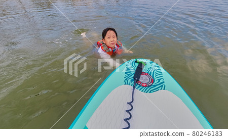 A cute child playing SUP board in the summer sea - Stock Photo ...
