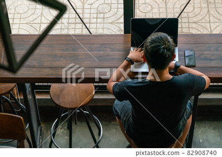 Young man typing on laptop - Stock Photo [82908740] - PIXTA