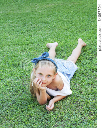 Little girl lying on green grass - Stock Photo [84867704] - PIXTA