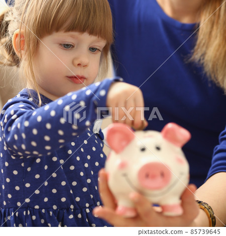 Little child girl with mom throws coins into... - Stock Photo [85739645 ...