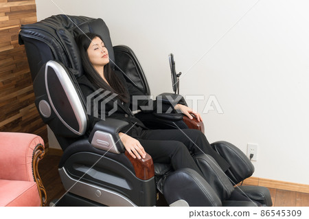 Young woman sitting in a massage chair and... - Stock Photo [86545309 ...