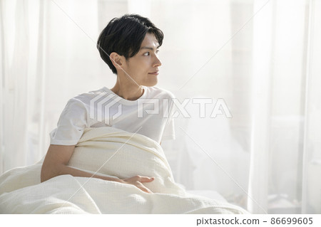 Image of a young man getting up on the bed - Stock Photo [86699605] - PIXTA