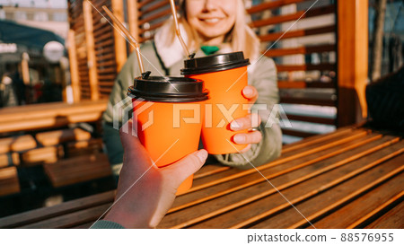 Two friends clink paper cups with mulled wine... - Stock Photo ...