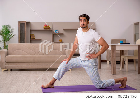 Young man doing sport exercises at home - Stock Photo [89728456] - PIXTA
