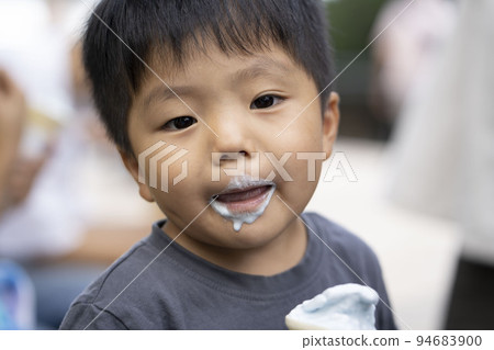 Boy happily eating soft serve ice cream - Stock Photo [94683900] - PIXTA