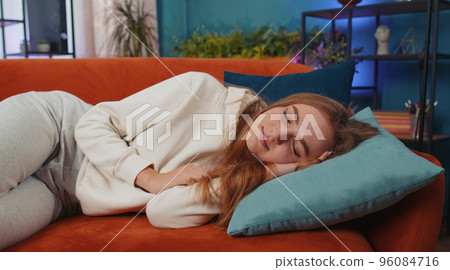 Tired young woman lying down in bed taking a... - Stock Photo [96084716 ...