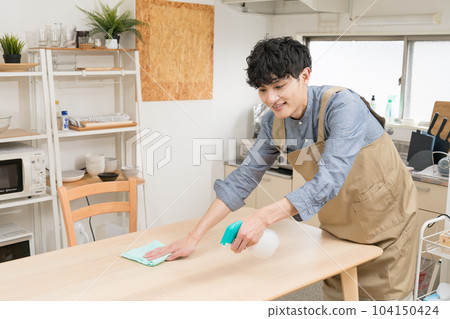Young man wiping the table in the kitchen dining - Stock Photo ...